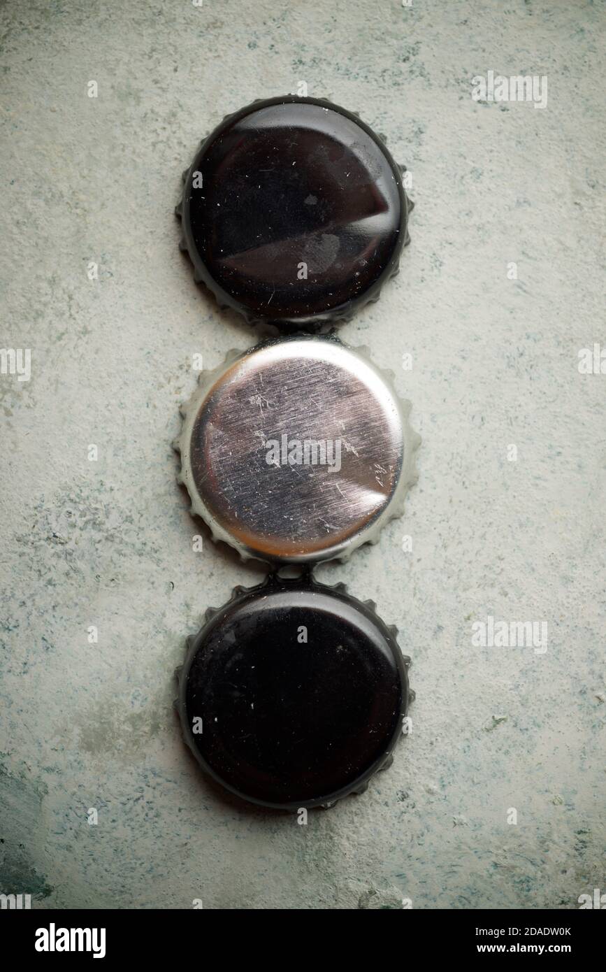 Collection of bottle caps on a stone table Stock Photo - Alamy