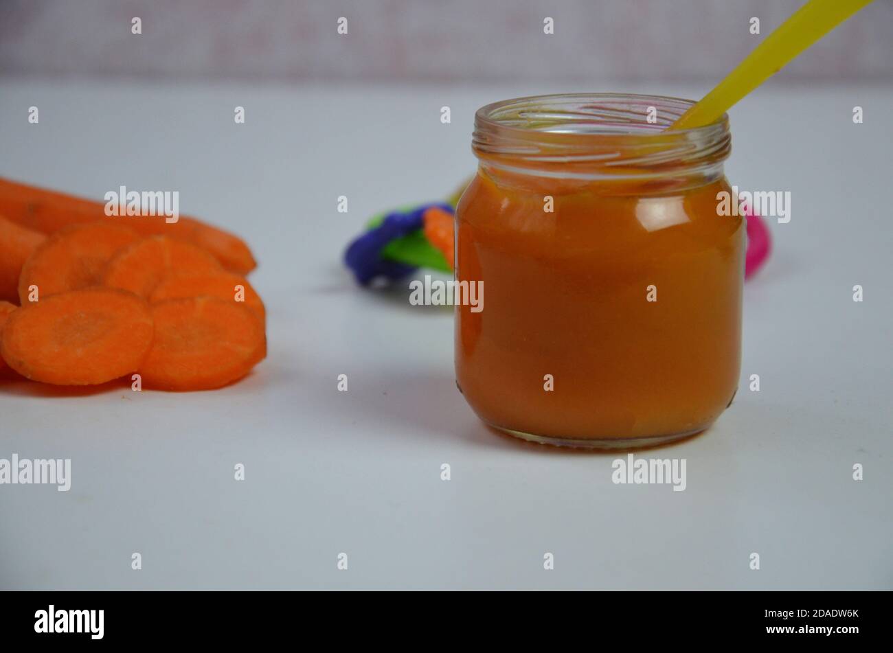 baby mashed with spoon in glass jar on white background Stock Photo - Alamy