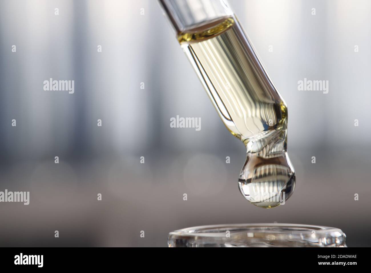 Drop of clear liquid drips into test tube Stock Photo - Alamy