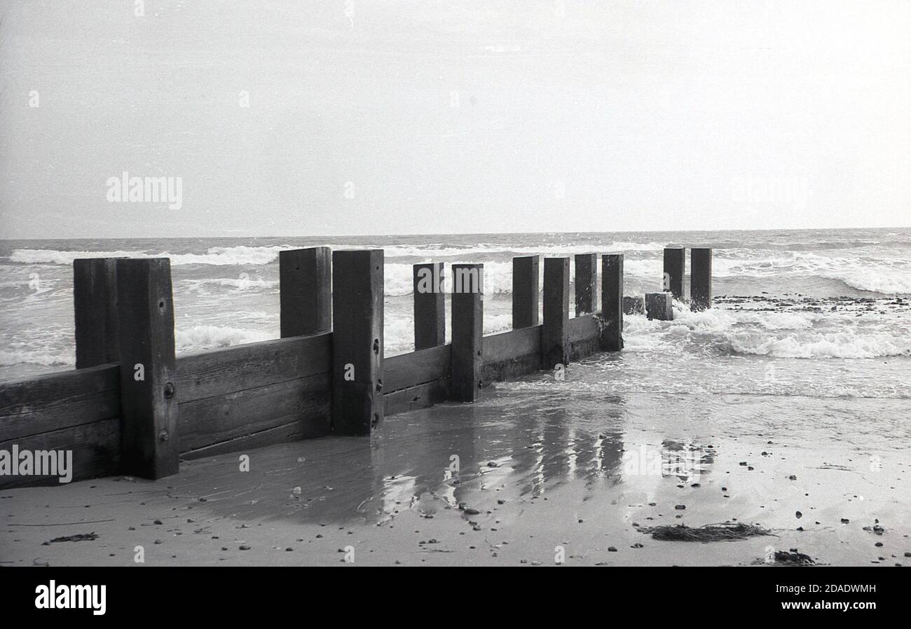 Wooden sea breakers on beach, made from old railway sleepers, 1960s ...
