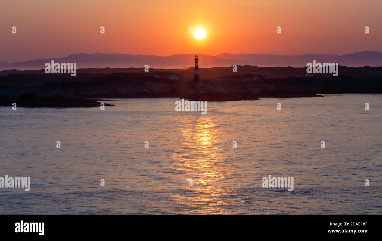 Norwegian sunset over the sea with a lighthouse in the background Stock ...
