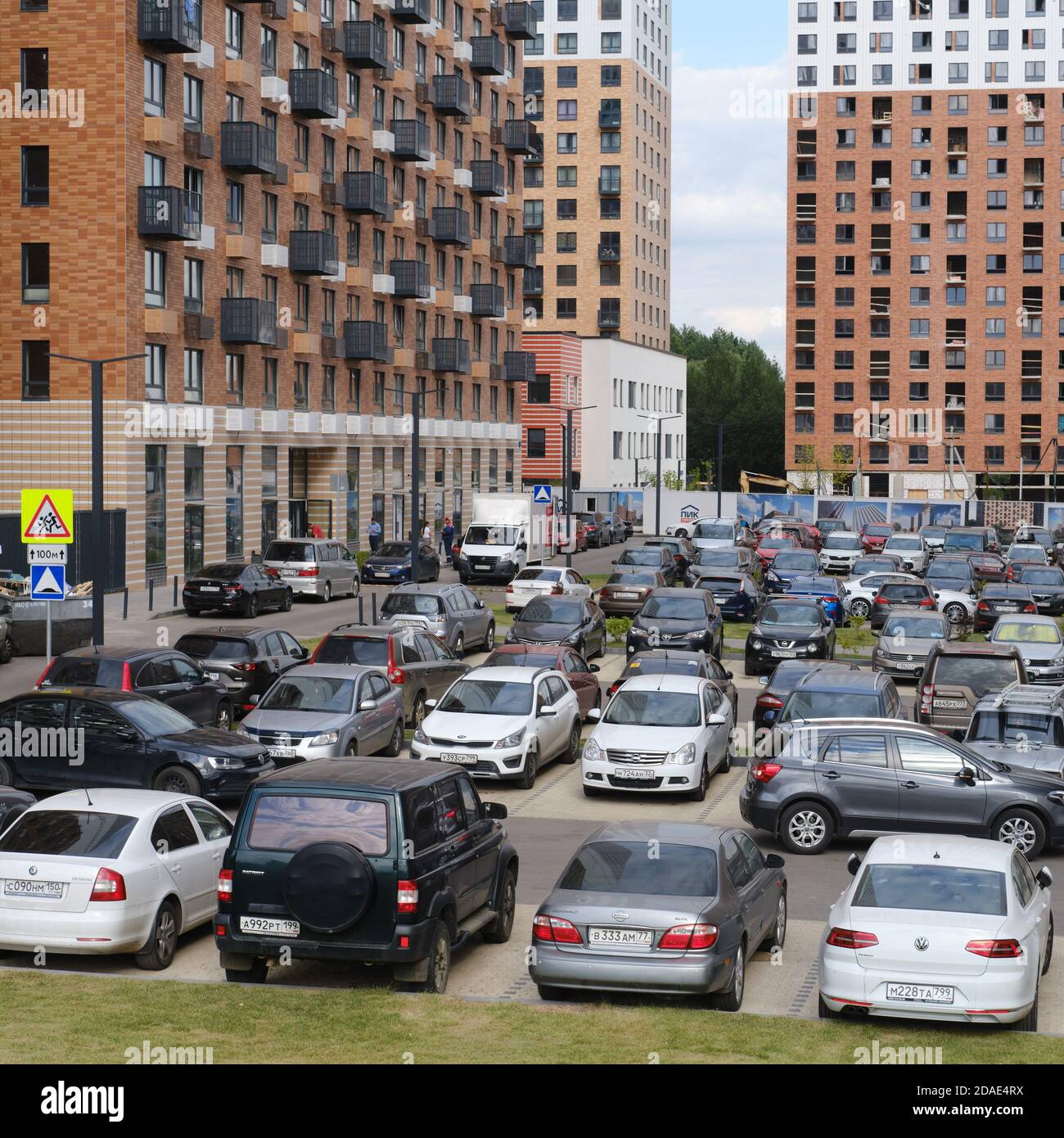 Cars are parked in the Parking lot near the unfinished new building ...