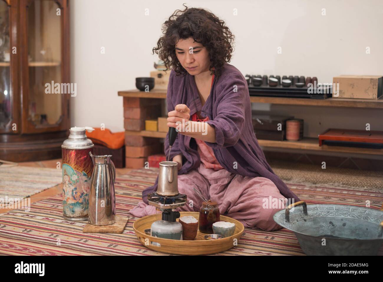 Asian woman with curly hair prepares tea Stock Photo - Alamy