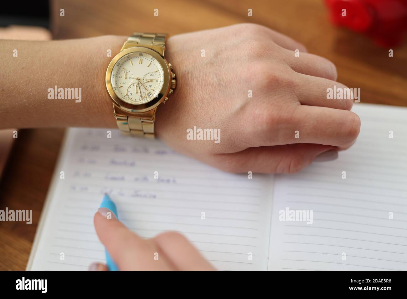 Woman's hand with watch pen next to it lies diary Stock Photo - Alamy