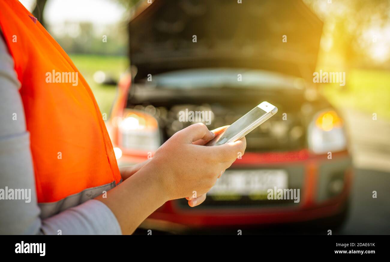 Young woman calling the car assistance during car crash or problem ...