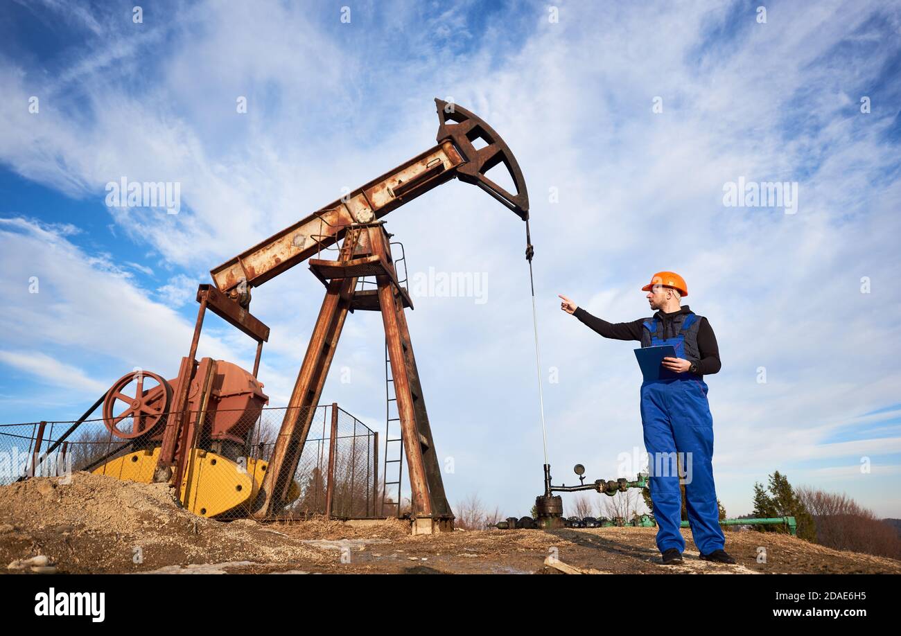 Horizontal snapshot of oil worker during his working day in oilfield ...