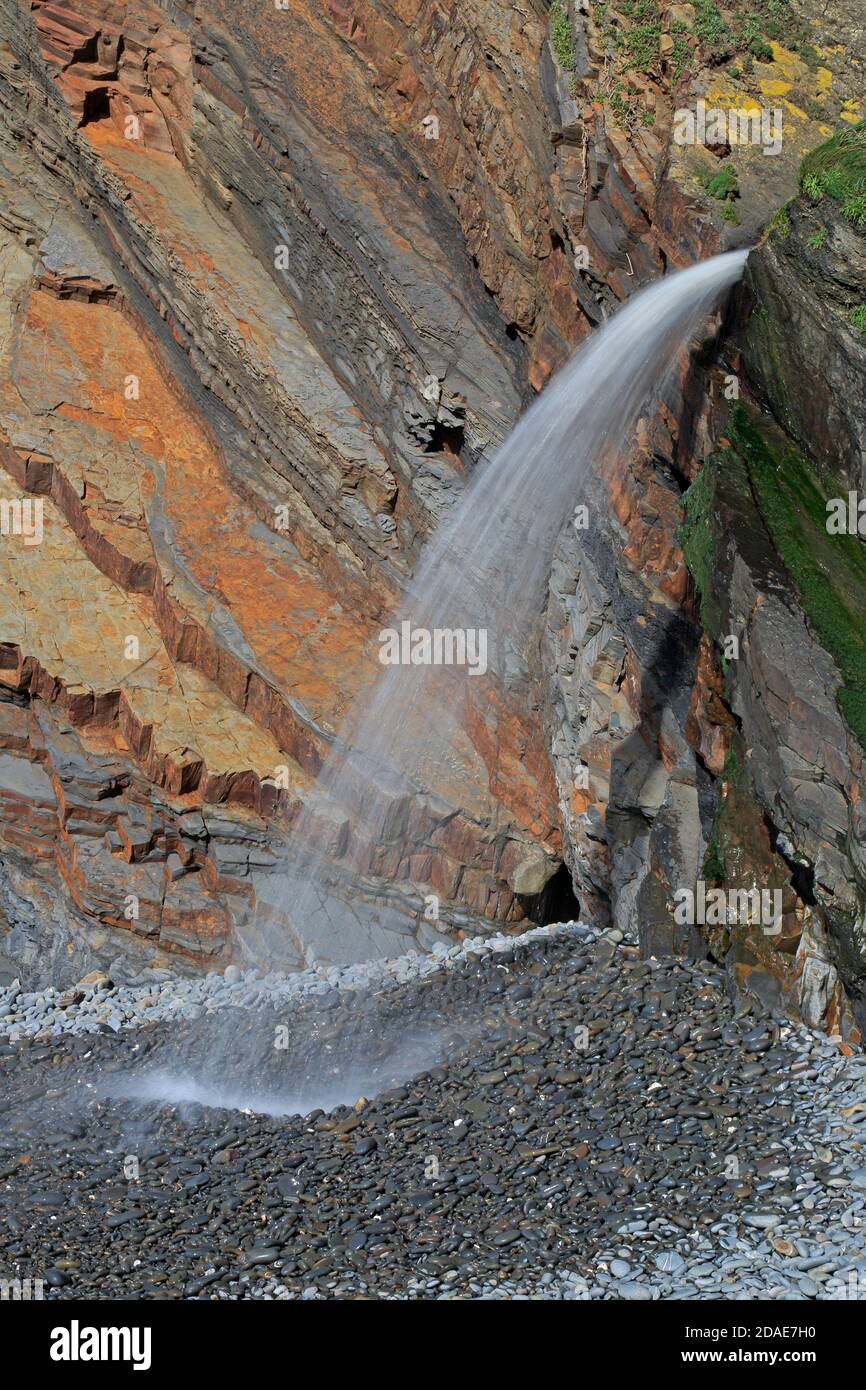 View of the waterfall cascading on to the beach at Sandymouth Cornwall ...