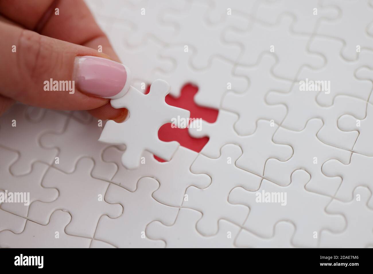 Womans hand placing last piece of puzzle on table closeup Stock Photo ...