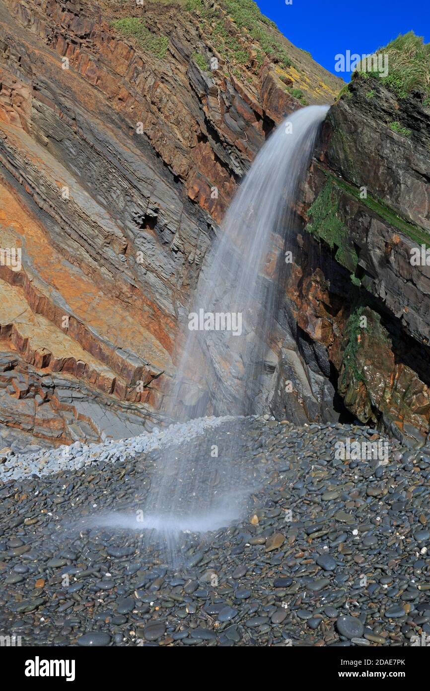 View of the waterfall cascading on to the beach at Sandymouth Cornwall ...