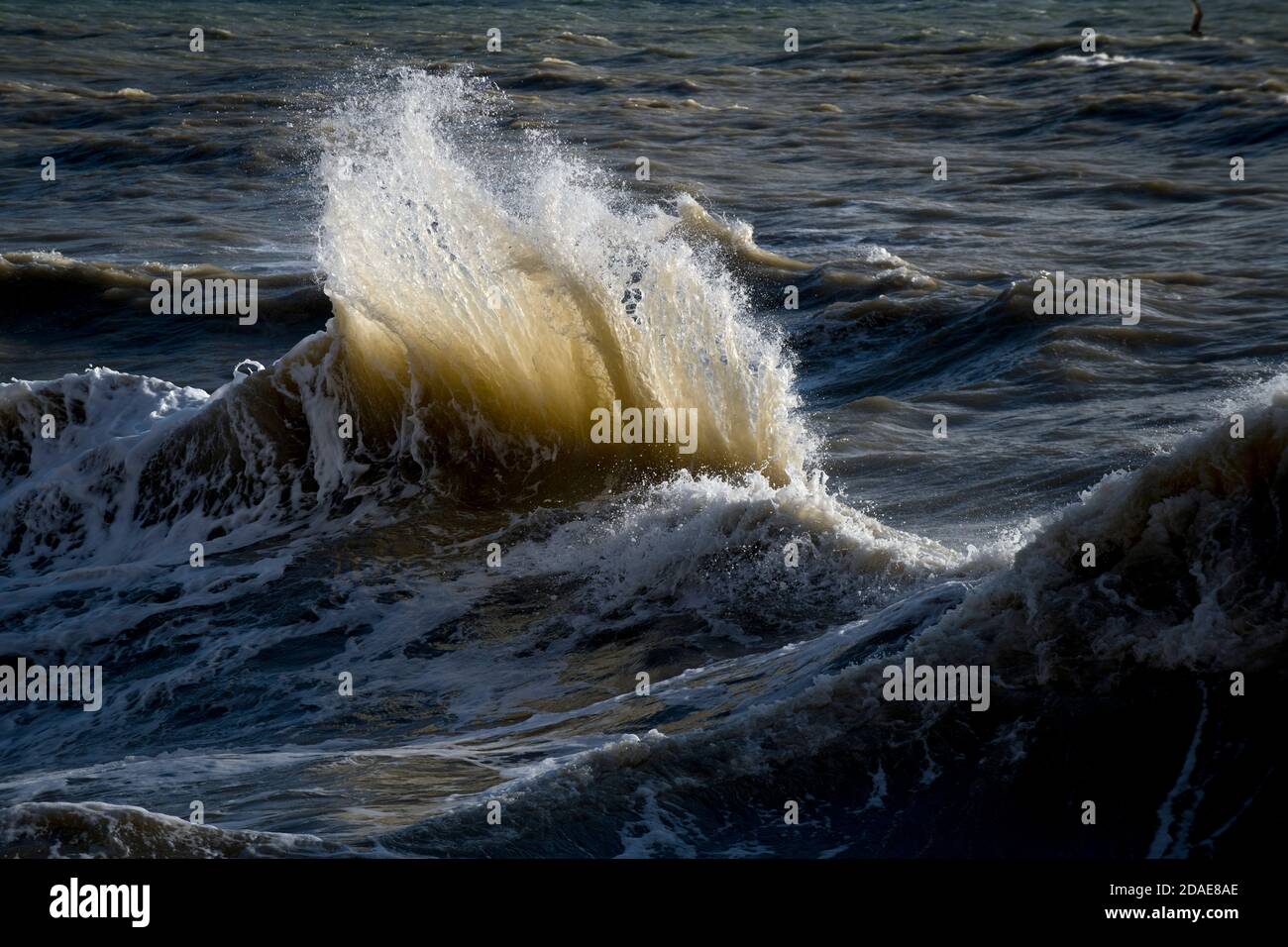 Stormy waves, backlit by low sunshine, in the English Channel on a ...