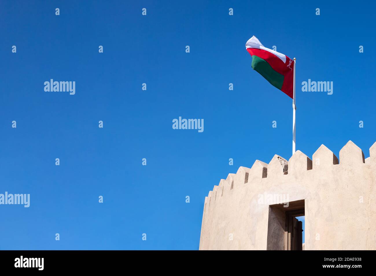 Flag on roof of fort in Oman. Blue sky copy space Stock Photo - Alamy