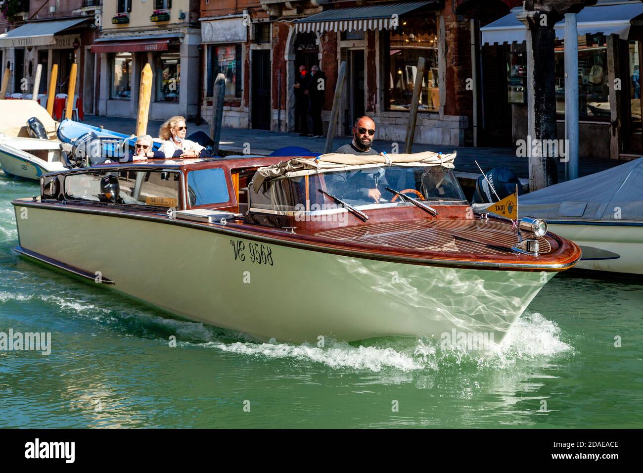 A Private Water Taxi Travelling Along A Canal On Murano Island, Venice ...