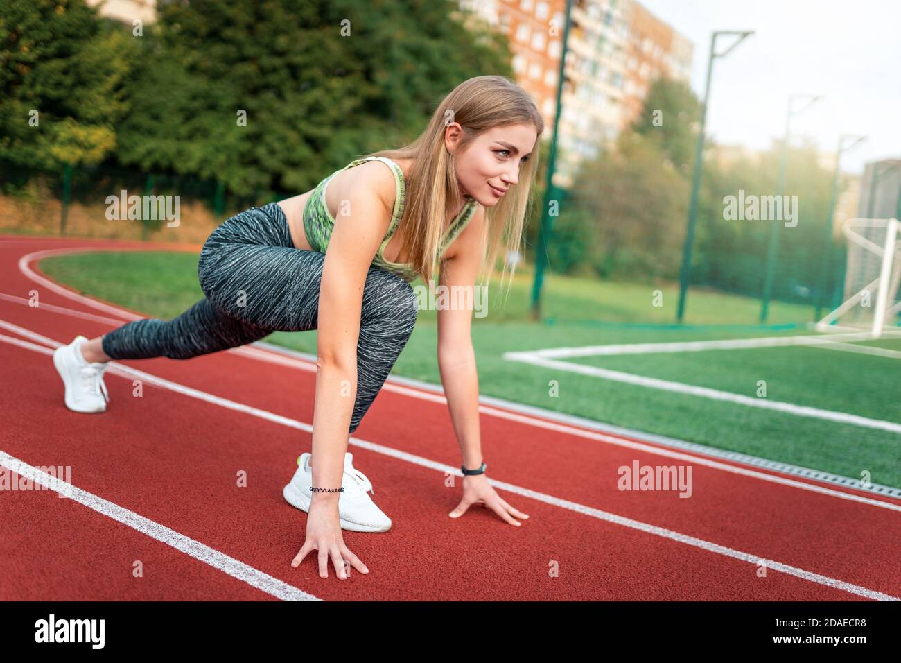 Positive girl at low start getting ready to run Stock Photo - Alamy