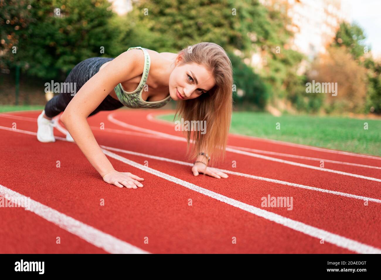 Athletic girl stands in the plank at the stadium runway Stock Photo - Alamy