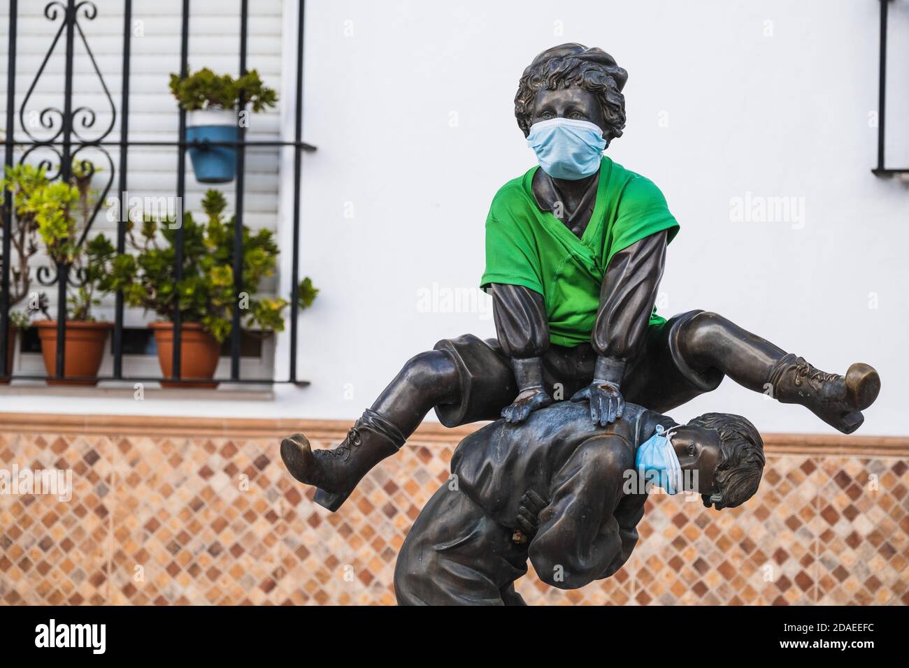 Bronze statues of two children playing in the street jumping on top of ...
