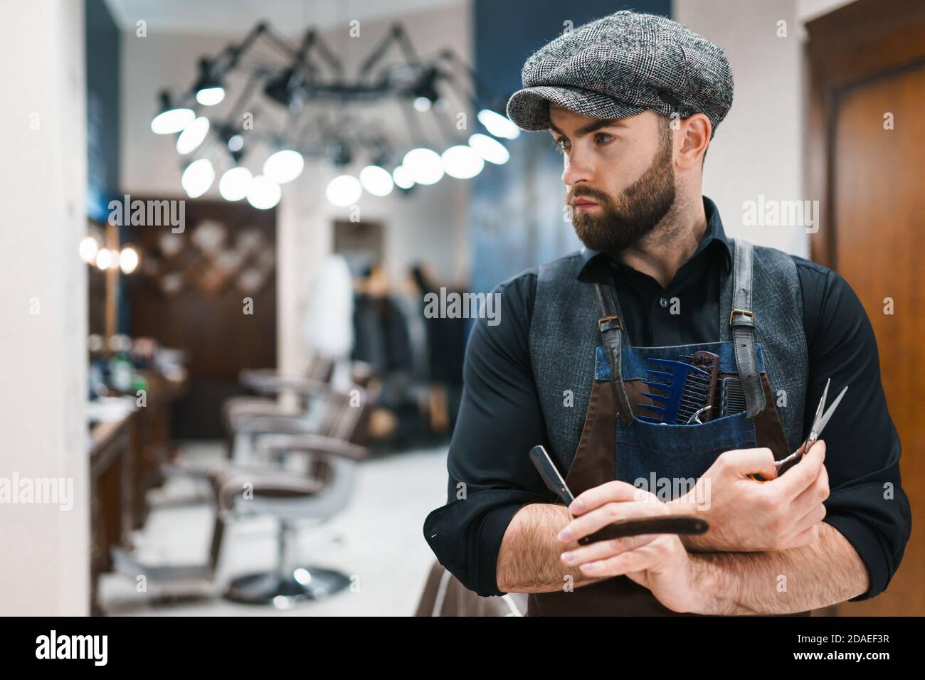 Serious barber with scissors and razor in hands Stock Photo - Alamy