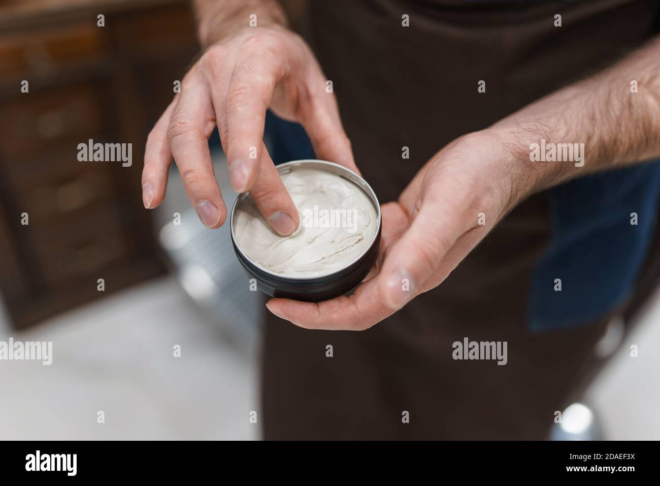 Hairdresser using pomade to hair styling Stock Photo - Alamy
