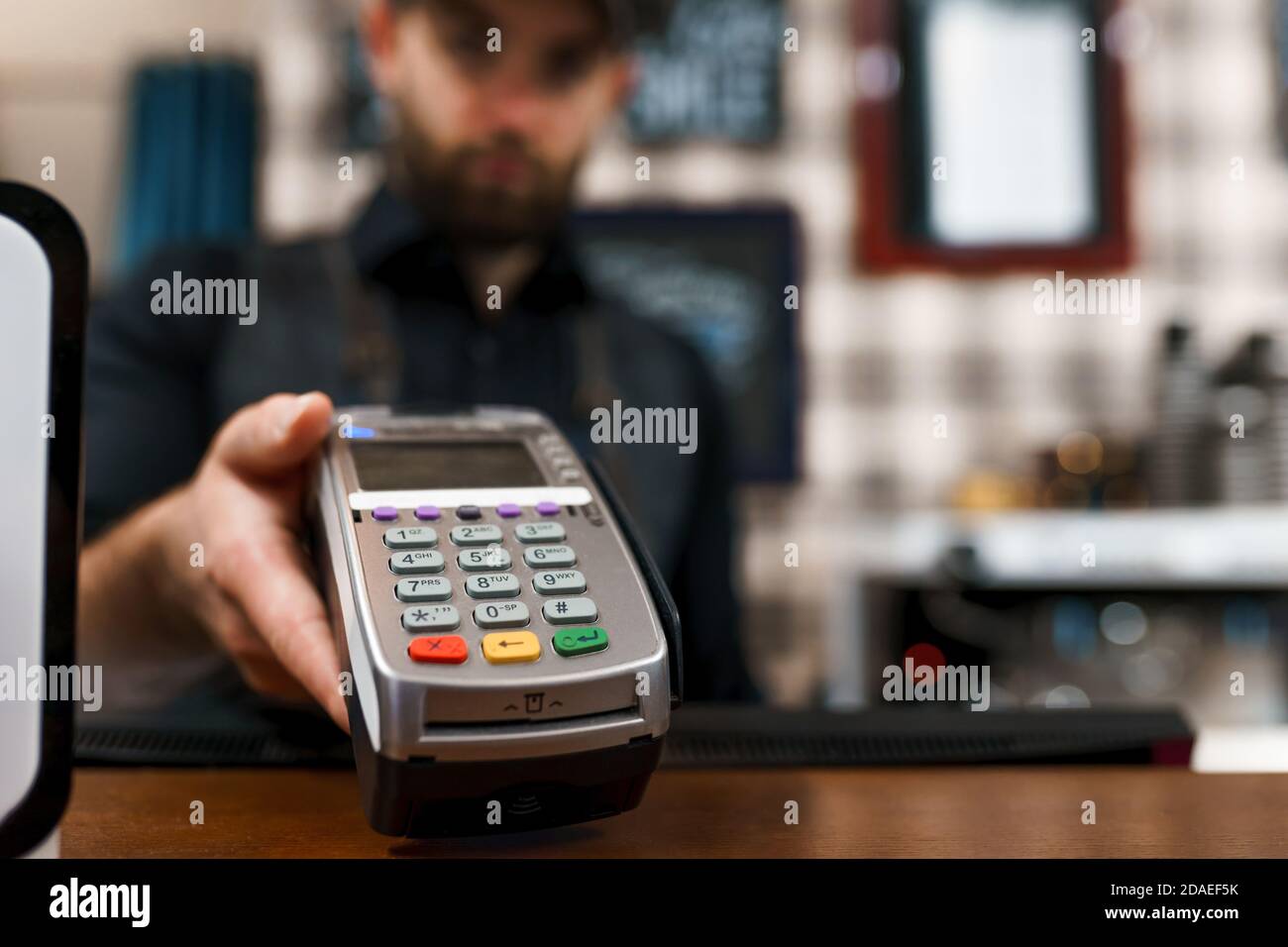 Cashier gives the client a payment terminal Stock Photo - Alamy
