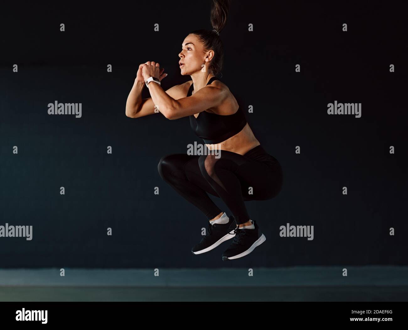 Sports woman jumping in gym. Muscular fit woman exercising indoors ...