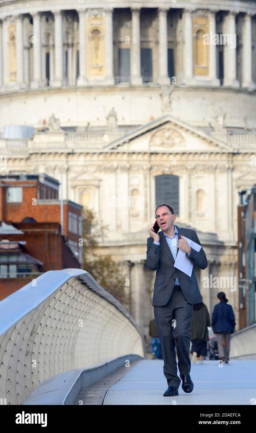 London, England, UK. Man walking over the Millennium Bridge, talking on ...