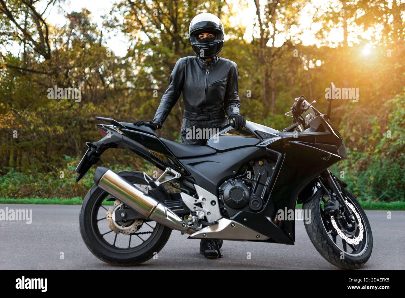 Female biker girl stands near the motorcycle Stock Photo - Alamy