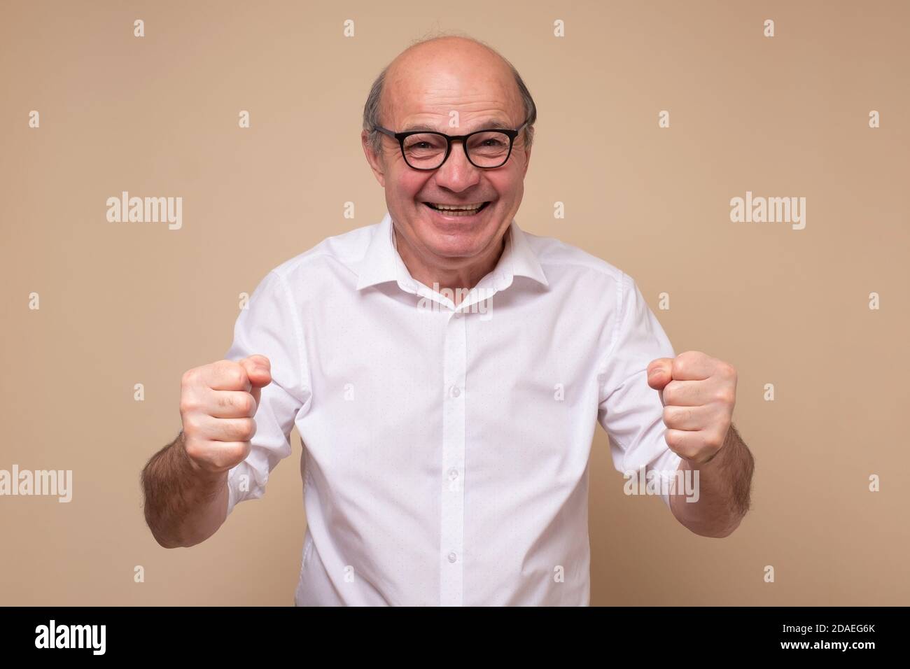 Senior caucasian man screaming Yes and raising clenched fists in the ...