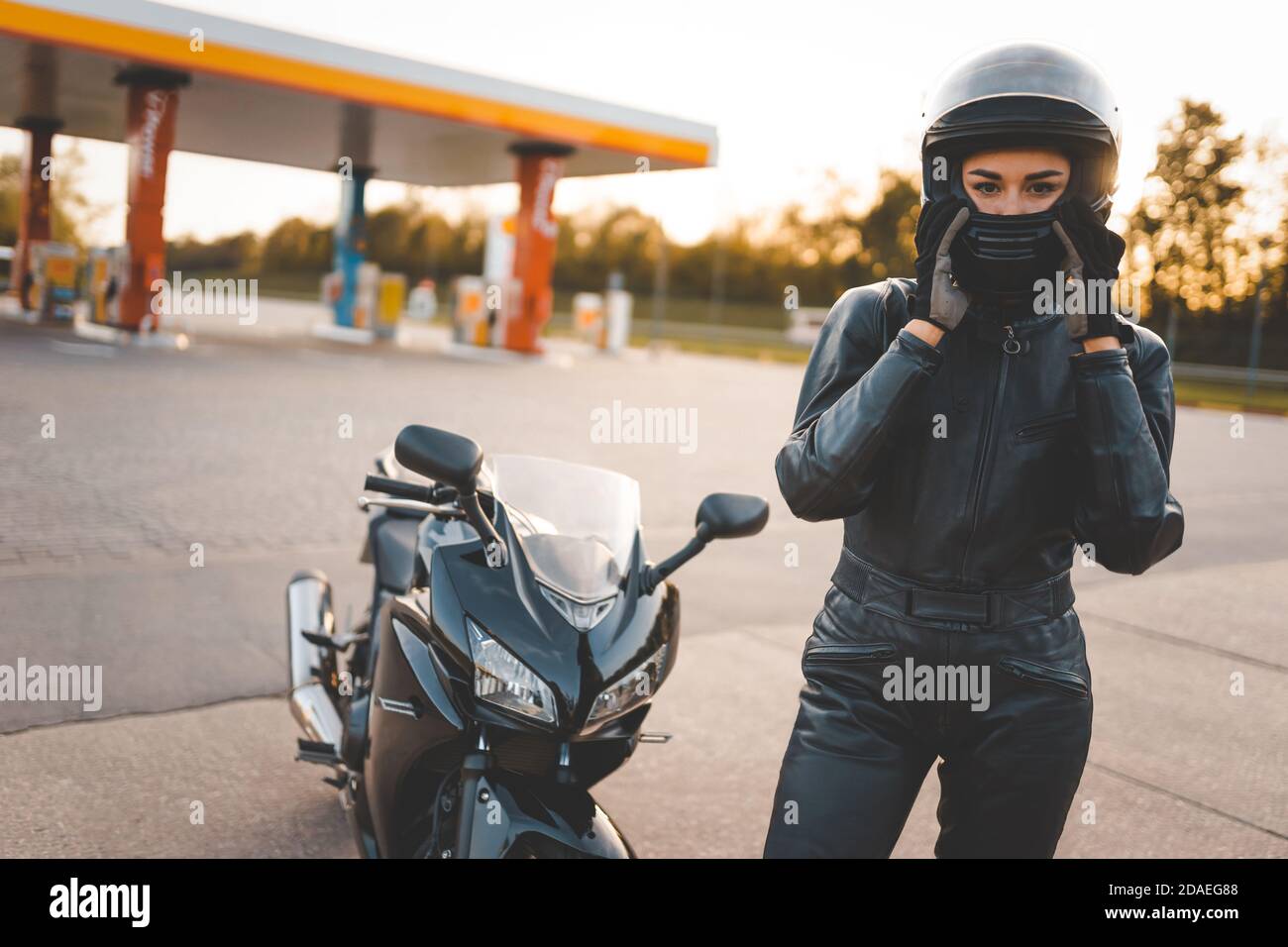 Brutal biker near motorcycle on the background of a gas station Stock ...