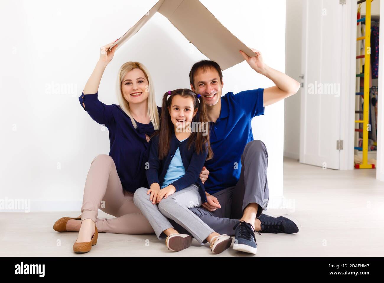 happy family sitting together and making the home sign Stock Photo - Alamy