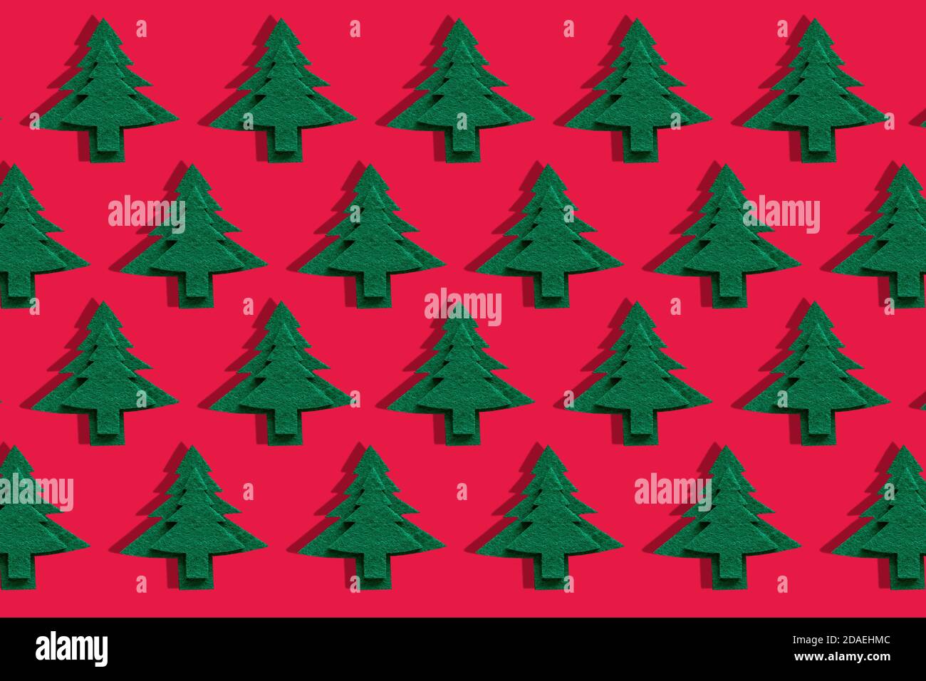 Christmas decorative trees on red surface. Object pattern of holiday ...