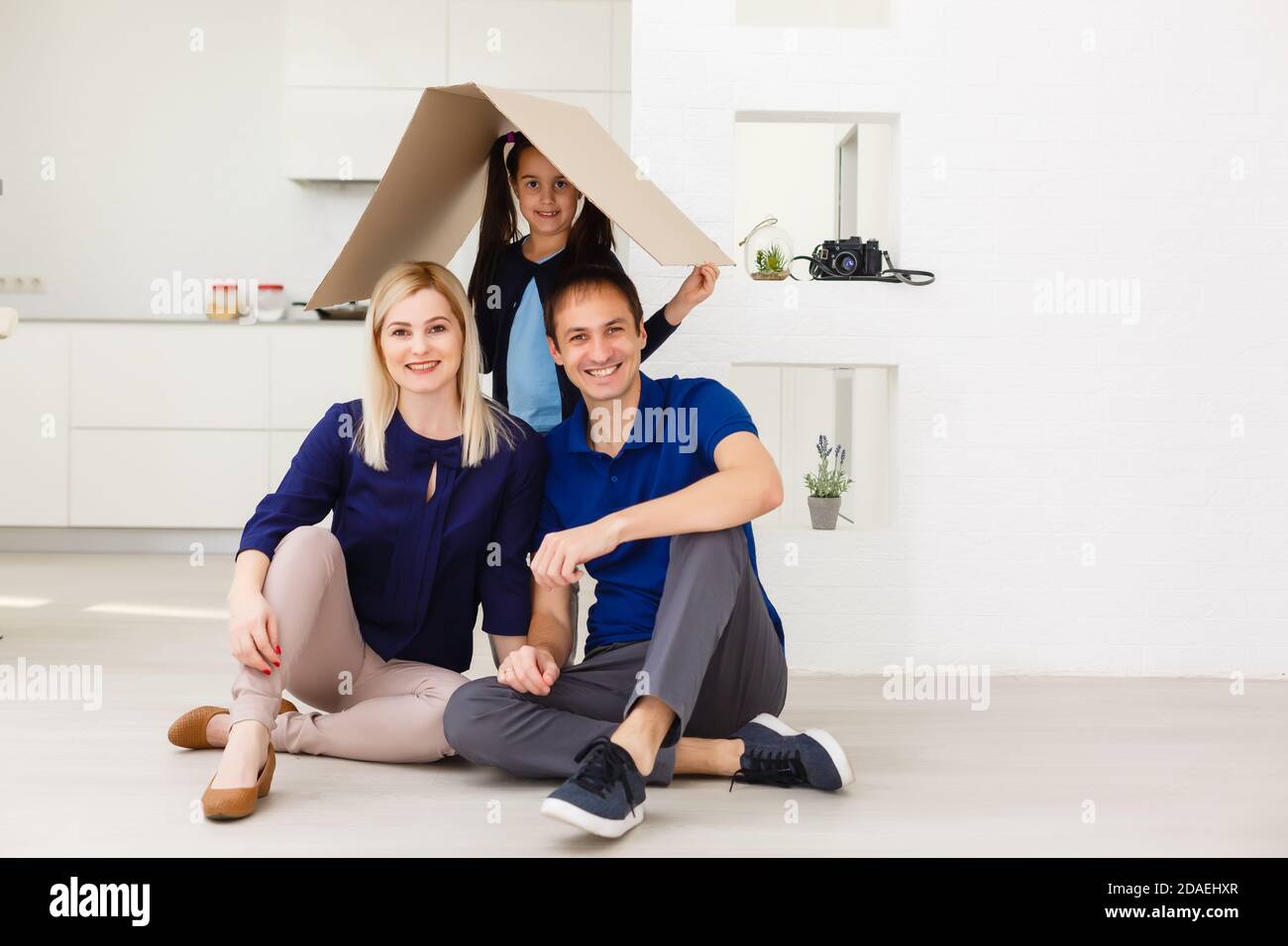 happy family sitting together and making the home sign Stock Photo - Alamy