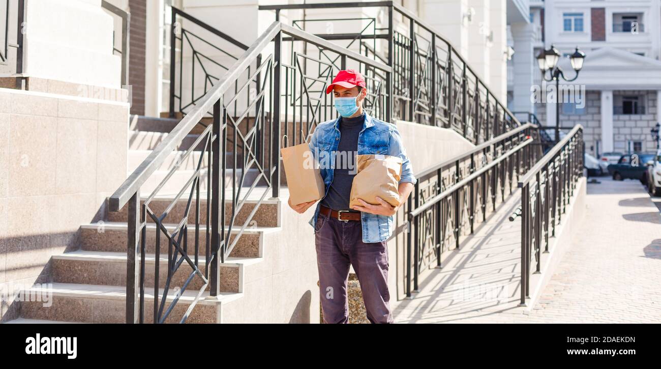 delivery guy in protective mask near the customer house, outdoors Stock ...
