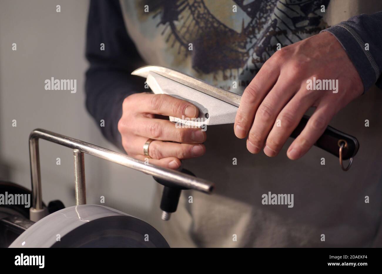 Knife sharpener and hand with blade Stock Photo - Alamy