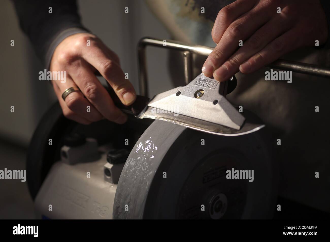 Knife sharpener and hand with blade Stock Photo - Alamy