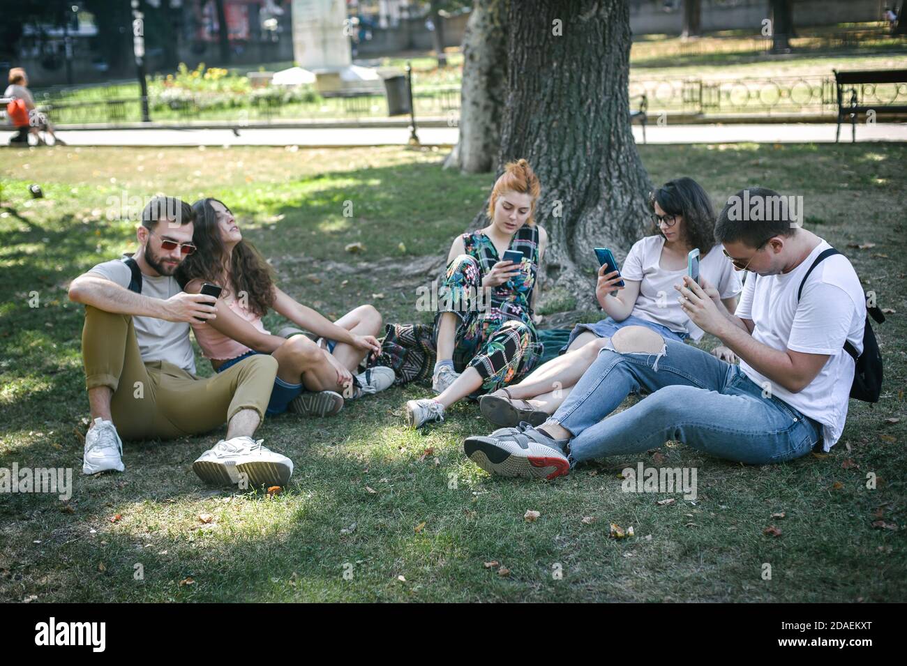 Group of friends using smartphones together. Young people addiction to ...