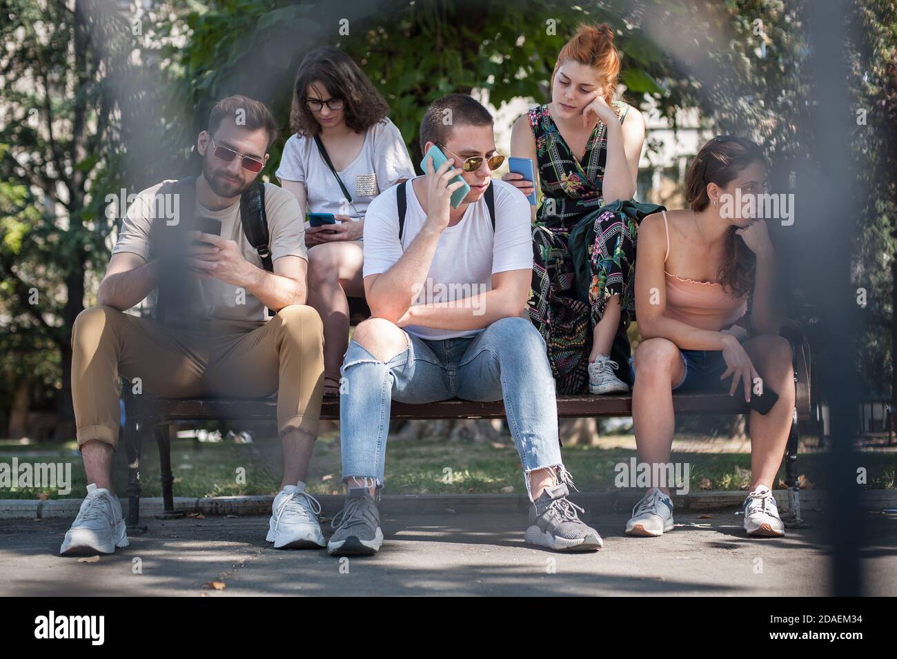 Group of friends using smartphones together. Young people addiction to ...