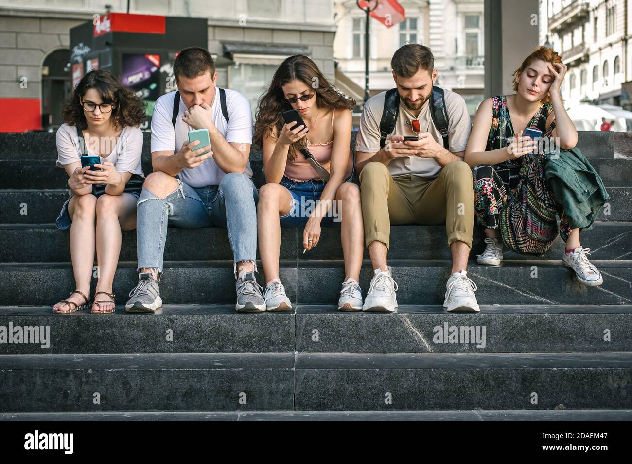 Group of friends using smartphones together. Young people addiction to ...