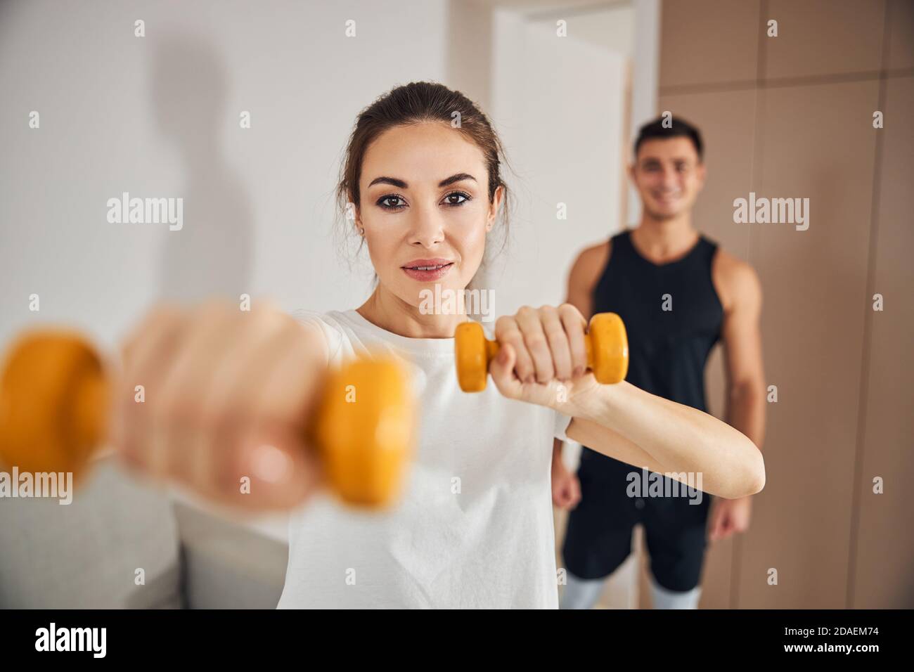 Fit young woman doing arm workout with her boyfriend Stock Photo - Alamy