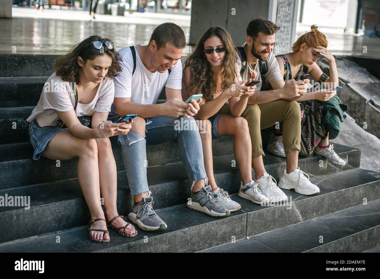 Group of friends using smartphones together. Young people addiction to ...