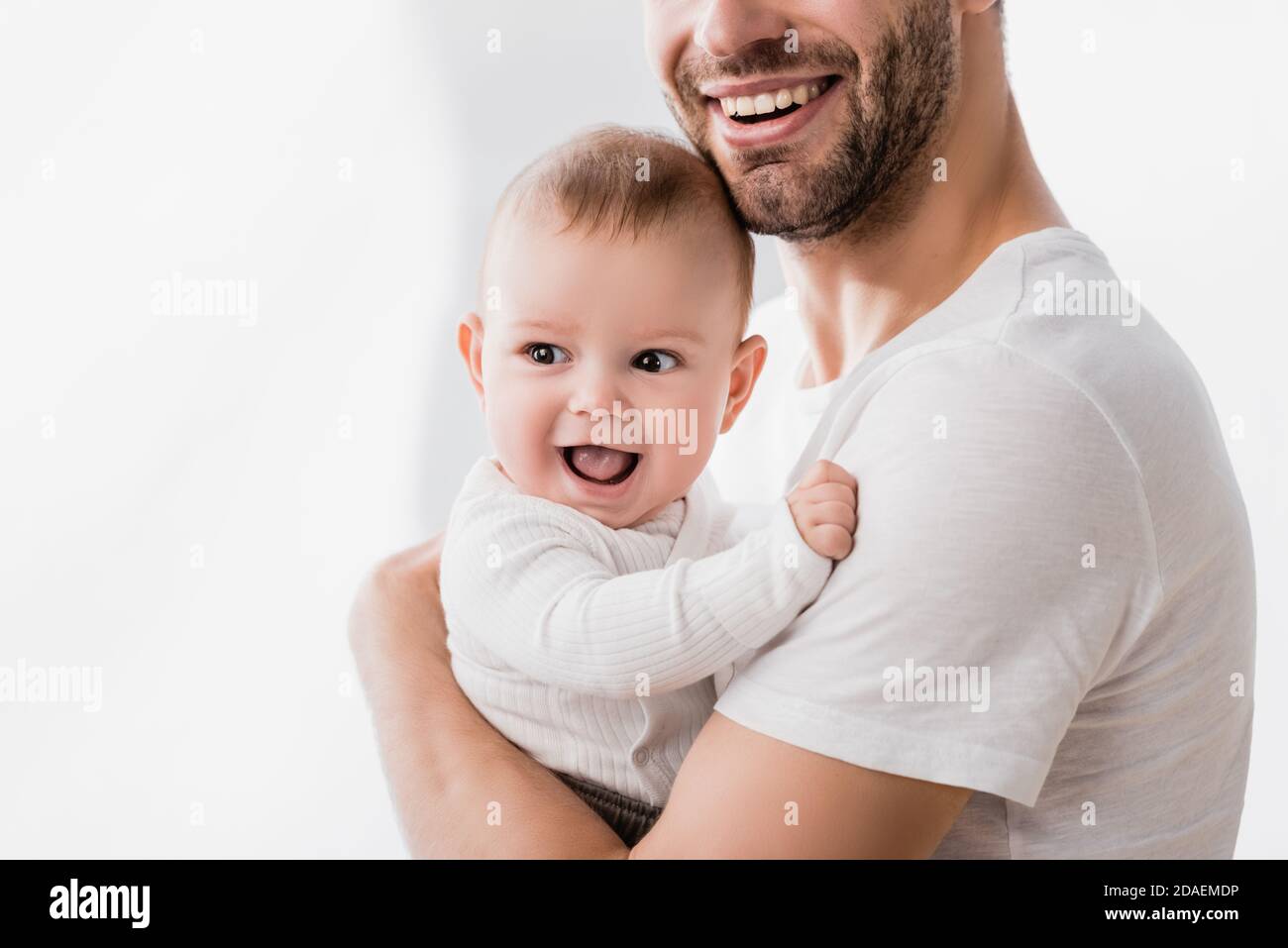 happy father holding in arms excited baby boy with open mouth Stock ...