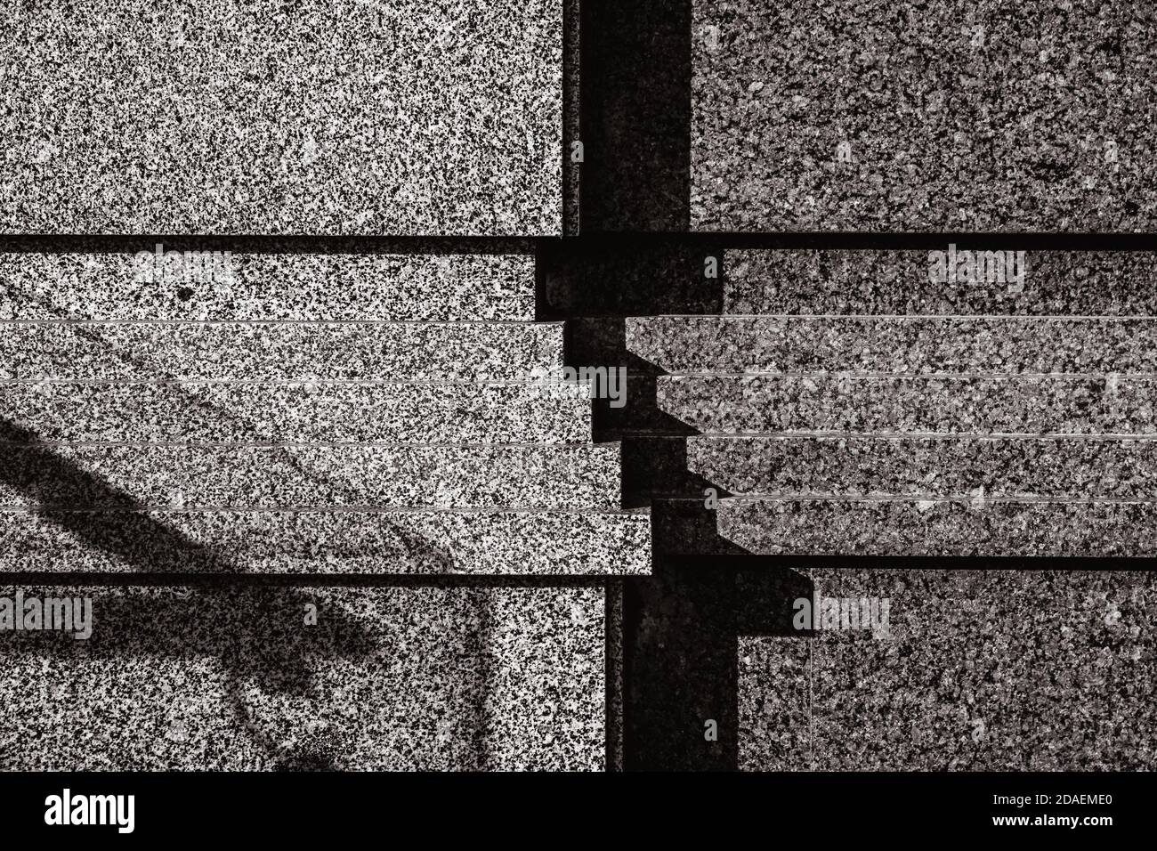 Light and shadows on the surface of granite wall of building. Close up ...