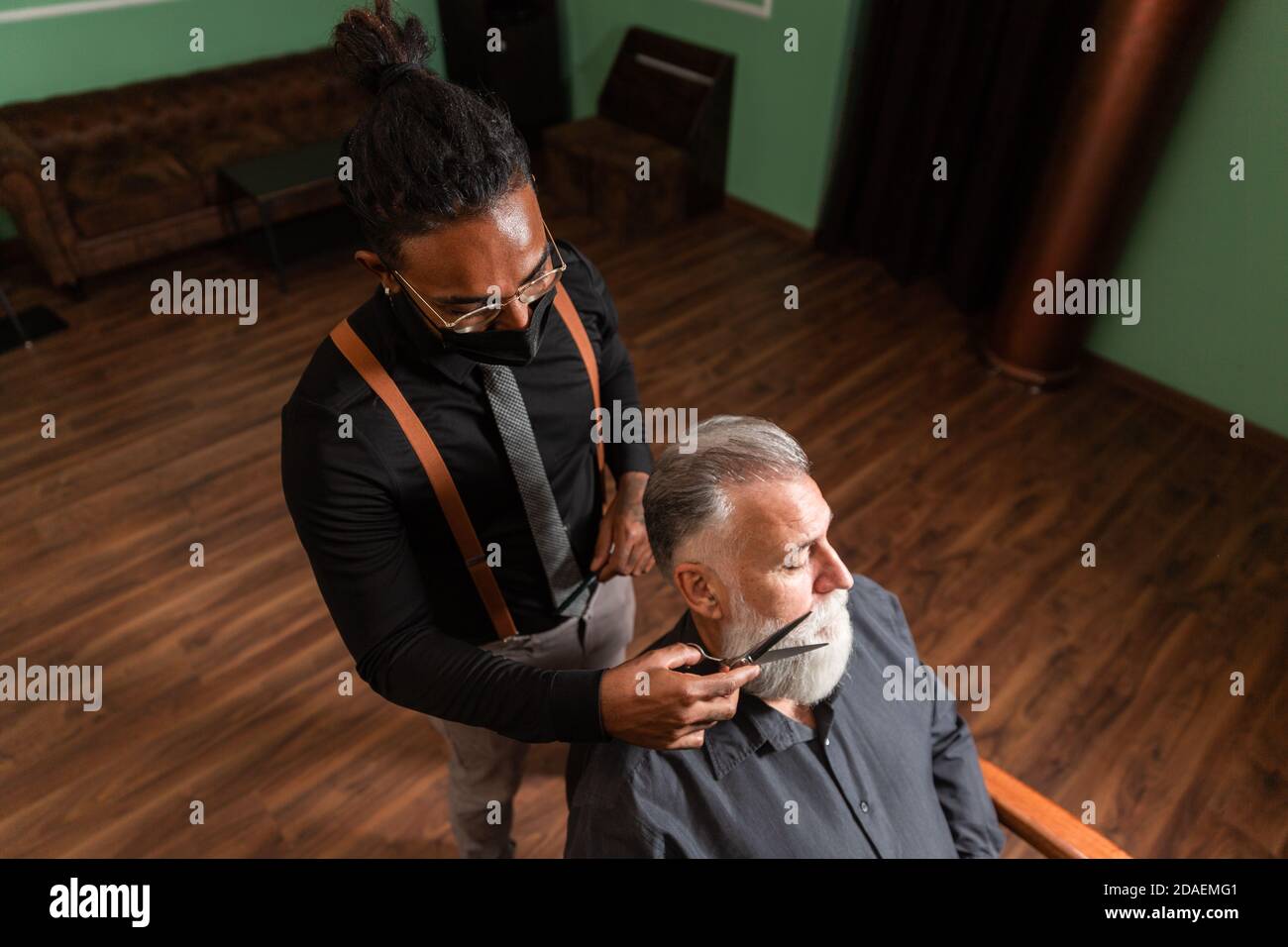 African-American barber trims graying white beard to older Caucasian ...