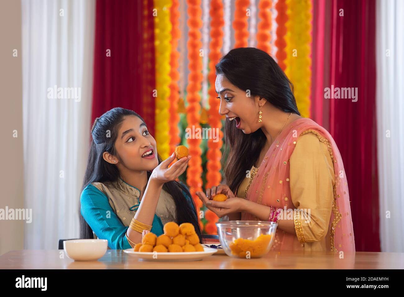 Daughter offering sweets to her mother Stock Photo - Alamy