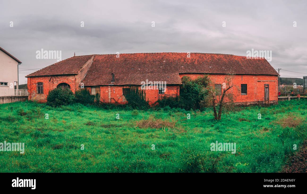 Old brick building on the grass-covered meadow Stock Photo - Alamy