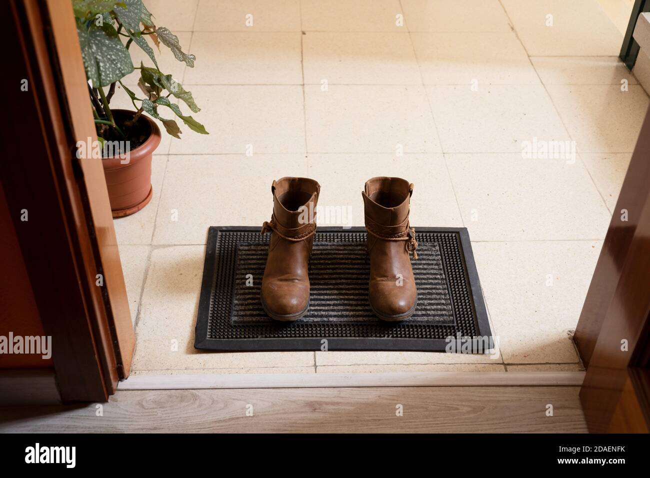 Boots at the entrance of the house on the doormat Stock Photo - Alamy