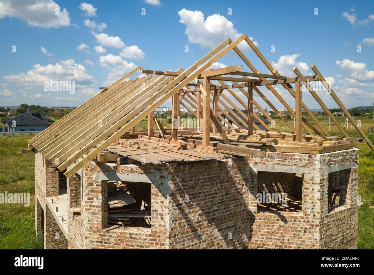 Aerial view of unfinished house with wooden roof frame structure under ...