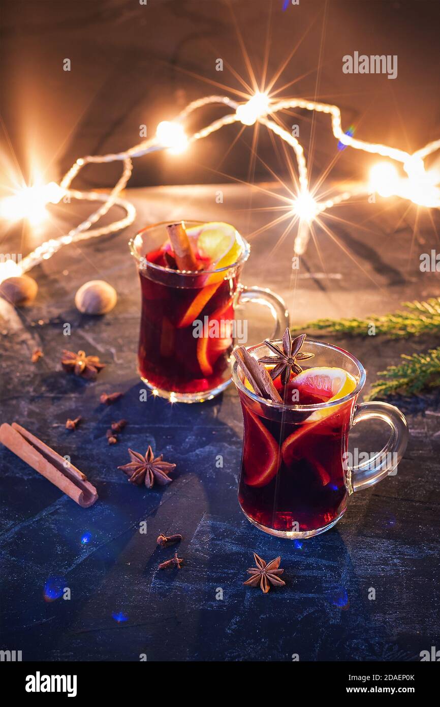 Hot red mulled wine in glass with orange, cinnamon sticks, cloves and ...