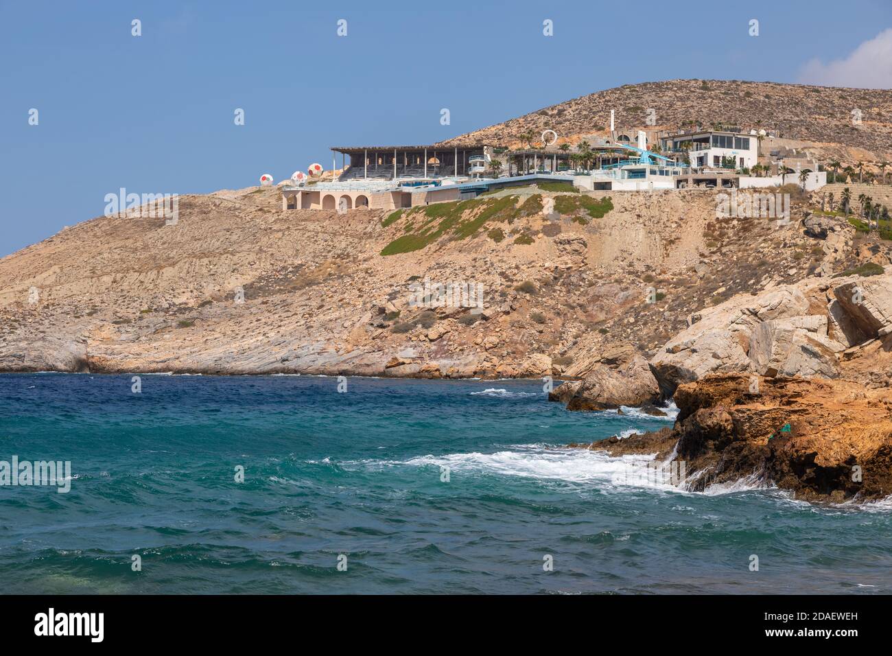 Rocky coast on the north side of the island of Ios. A white ...