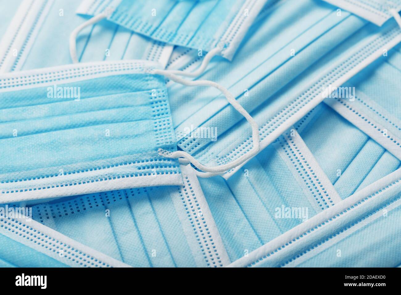 Blue medical protective masks are scattered as a background, texture ...