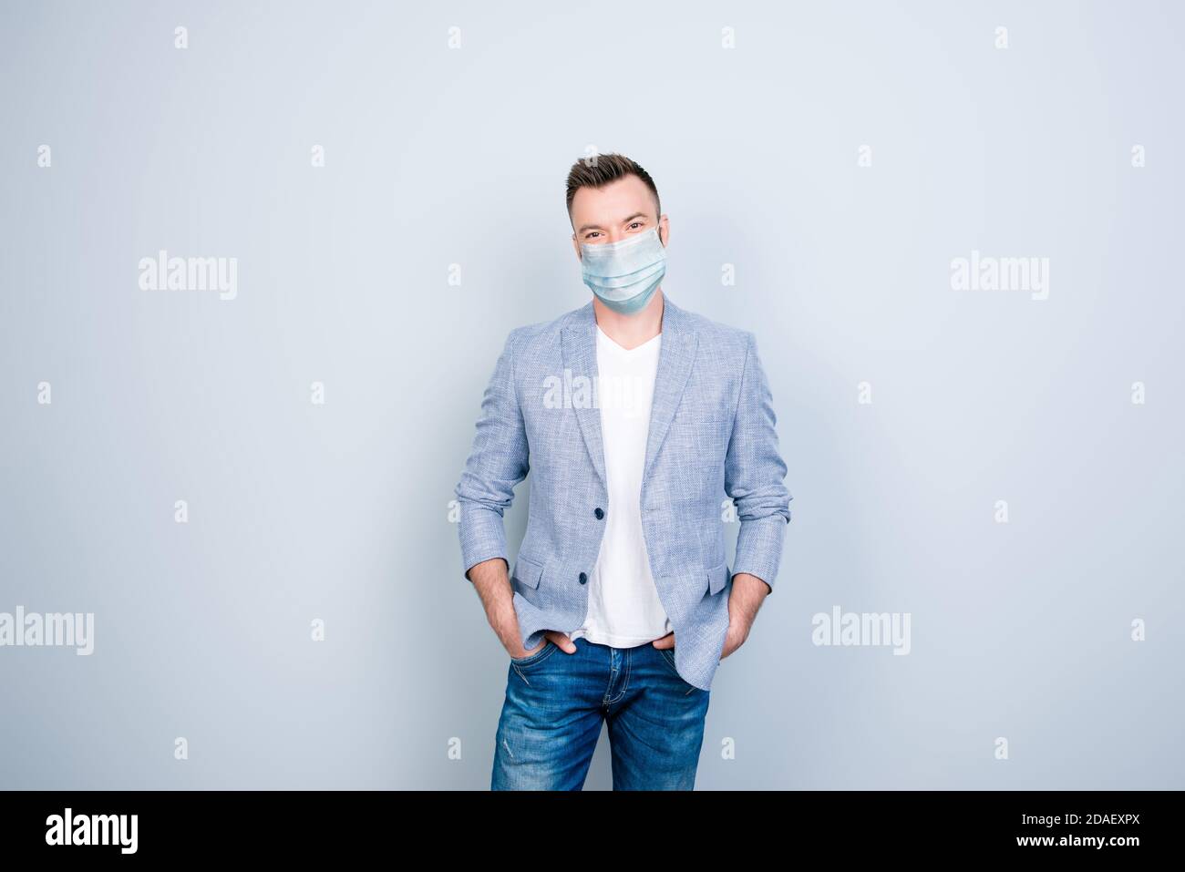 Photo portrait of guy with hands in pockets wearing blue face mask ...