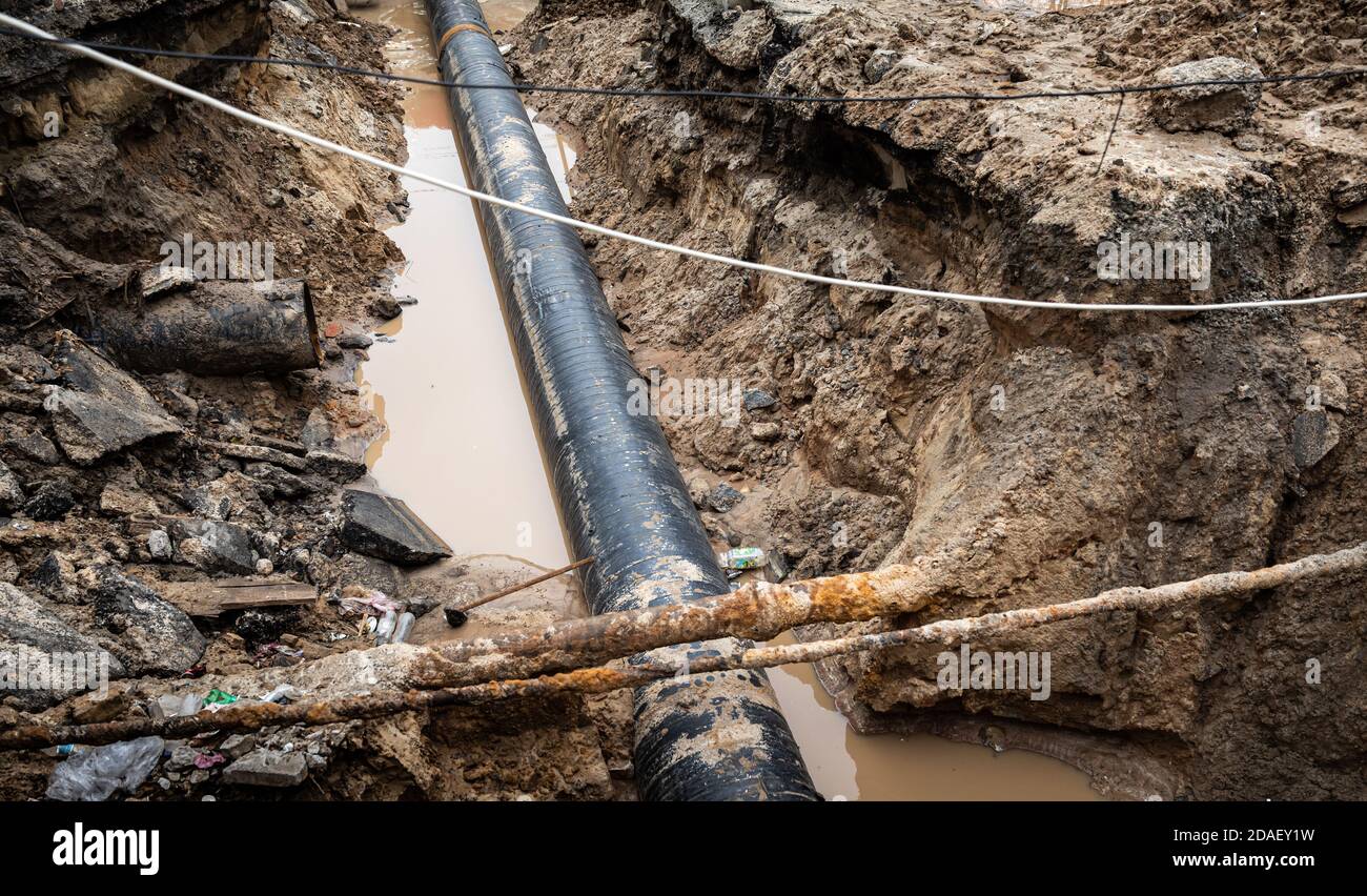 Repair of roads and underground utilities. Big trench on the road with ...